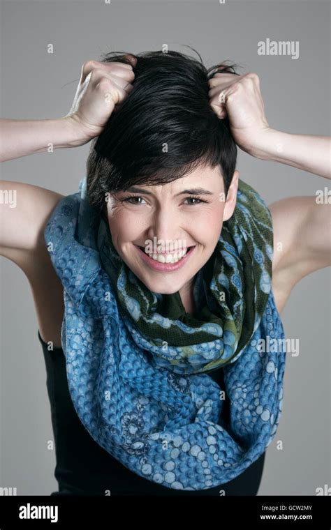 Angry Young Cute Short Hair Woman Pulling Hair With Clenched Teeth Looking At Camera Over Gray