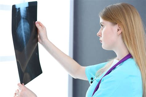 의사 여자 외과 의사 진료소 또는 병원에 창문 가까이 서 있는 동안 X 선 사진 검사 의학 및 건강 관리 개념입니다 직장에서