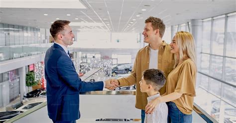 유쾌한 백인 컨설턴트는 자동차 쇼룸에서 고객을 돕게되어 기쁘고 정장을 입은 잘 생긴 세일즈맨은 고객과 대화를 나눕니다 사진 Unsplash의 소매 이미지