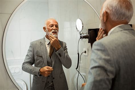 그의 회색 수염을 만지는 욕실에서 옷을 입고 있는 사업가 남자에 대한 스톡 사진 및 기타 이미지 남자 거울 넥타이 Istock