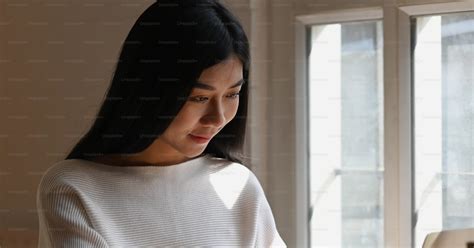 초상화는 도서관 테이블에서 노트북 컴퓨터를 사용하여 아시아 여성을 촬영했습니다 사진 Unsplash의 작동하는 노트북 이미지