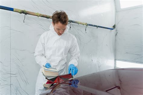 남자는 샘플을 사용하여 자동차 페인트 그늘을 선택합니다 차량 페인팅 부스에서 자동 컬러 25 29세에 대한 스톡 사진 및 기타