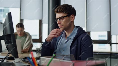 Premium Photo Thoughtful Programmer Looking Computer At Desk Focused