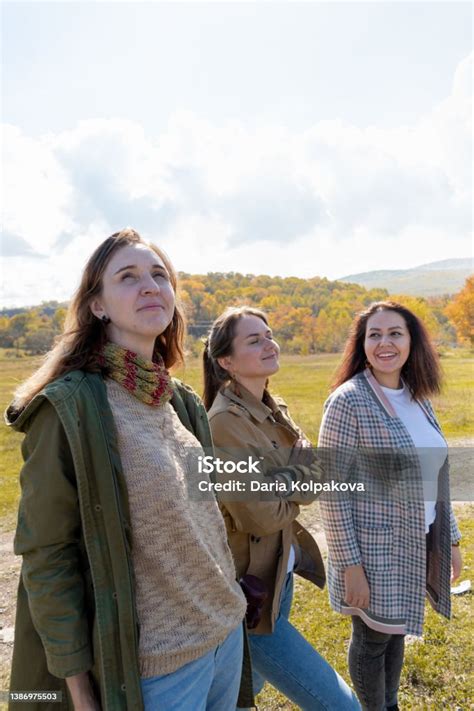 구름이 있는 푸른 하늘을 배경으로 녹색 잔디밭에서 달리는 세 명의 소녀 여자 친구 개념 3 명에 대한 스톡 사진 및 기타 이미지