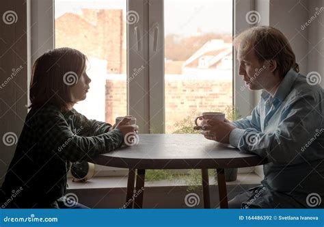 Отец и сын сидят на кухне за столом пьют кофе Стоковое Фото изображение насчитывающей люди