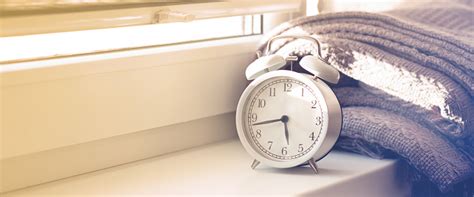 이른 아침 깨어 개념 복고풍 알람 시계 는 5 마흔 다섯을 보여주는 침대 덮개 창문 태양 광 효율적이고 편안한 하루를 위한 좋은 시작 닫기 흰색 배경 텍스트 공간 복사 가정