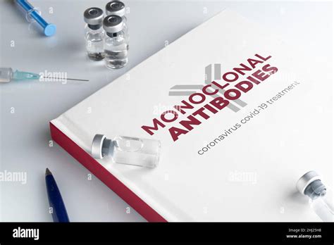Monoclonal Antibodies Concept A Book On A White Table With Some Vials
