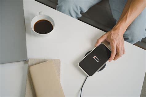 남자는 스마트폰에 충전기를 꽂고 있다 집에서 무선 충전 패드로 스마트폰 충전하기 충전에 대한 스톡 사진 및 기타 이미지 충전 플러그 어댑터 휴대전화 Istock