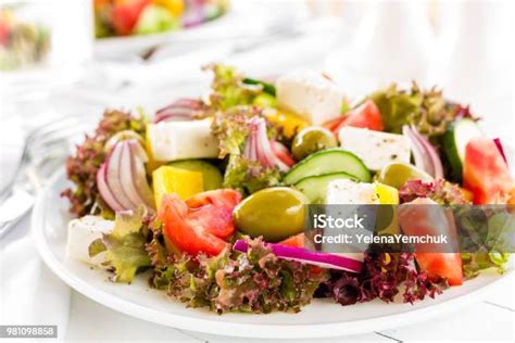 그리스 샐러드입니다 토마토 양파 오이 후추 올리브 양상추와 페타 치즈와 신선한 야채 샐러드 흰색 테이블에 접시에 그리스 샐러드 0명에 대한 스톡 사진 및 기타 이미지