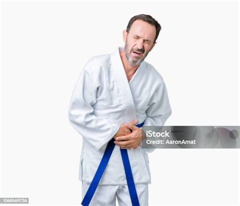잘생긴 중 년 수석 남자 이상의 기모노 유니폼을 입고 고립 속에 손으로 배경 때문에 구역 질 고통 스러운 질병 기분이 나쁘다 통증 개념입니다 가라테에 대한 스톡 사진 및