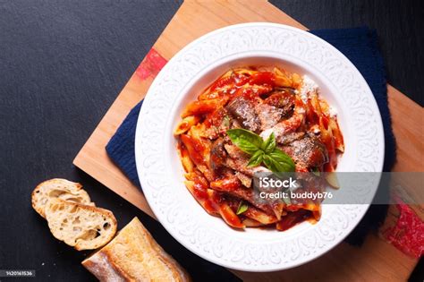 음식 개념 수제 유기농 시칠리아 파스타 알라 노마 펜과 복사 공간이있는 검은 배경에 나무 보드에 가지 토마토 소스를 곁들입니다 파스타에 대한 스톡 사진 및 기타 이미지