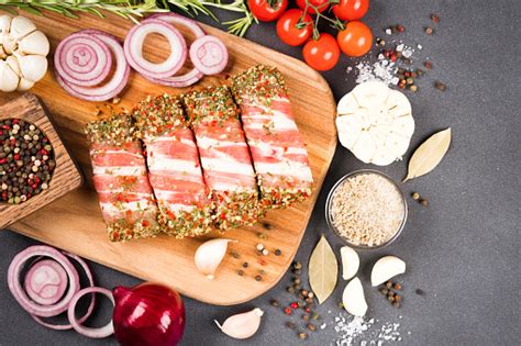 발칸 세바프치치 또는 루마니아 미티테이 전통적인 발칸 음식 어두운 콘크리트 배경 위에 조미료와 야채를 곁들인 베이컨으로 싸인 생 다진 고기 롤 가루로 빻은에 대한 스톡 사진