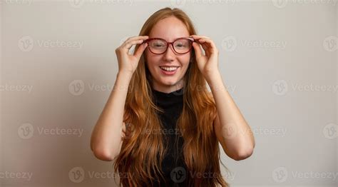 Beautiful Young Redhead Girl In Eyeglasses Is Looking At Camera And