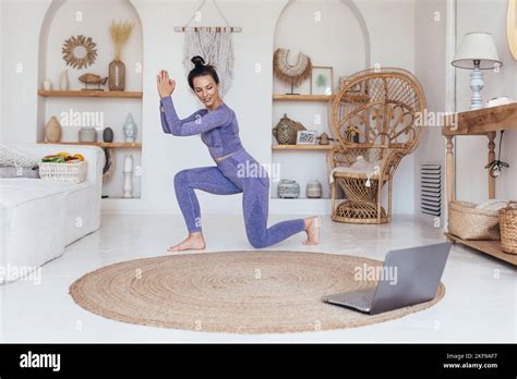 Woman Exercising Watching Online Videos On Laptop Doing Lunge