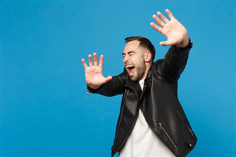 젊은 좌절 까만 자 켓 흰색 T 셔츠에 걱정 하지 않는 사람은 파란색 벽 배경 스튜디오 초상화에 고립 된 눈을 감고 비명 사람들은 진심으로 감정 라이프 스타일 개념입니다