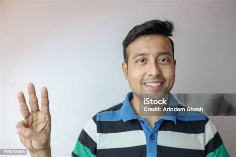 흰색 배경에 텍스트 복사 공간이 있는 세 개의 기호를 나타내는 자신감과 미소를 짓는 젊은 인도 남자 20 29세에 대한 스톡 사진 및 기타 이미지 Istock