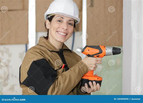 Constructor De Sexo Femenino Sonriente Con La Herramienta Del Taladro Foto De Archivo Imagen