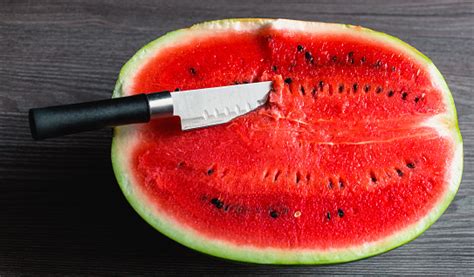 여름에 식탁에 칼로 자른 신선한 수박의 클로즈업 평면도 칼로 빨간색 잘 익은 수박 빨간 수박의 펄프에 날카로운 부엌 칼 건강한 식생활에 대한 스톡 사진 및 기타 이미지
