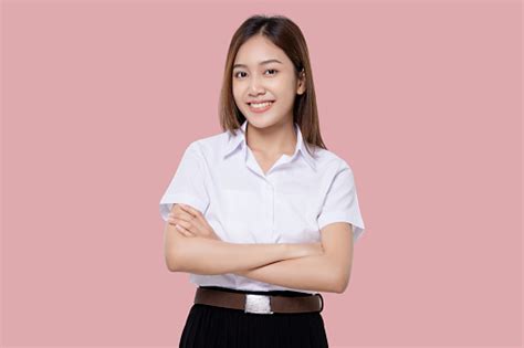 분홍색 배경에 고립 된 대학 유니폼을 입은 아시아 민족의 자신감있는 십대 학생 소녀 팔짱 낌에 대한 스톡 사진 및 기타 이미지 팔짱 낌 학생 18 19세 Istock