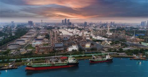 정유 공장 및 유조선 보트는 에너지 또는 가스 산업 또는 운송 배경을 위해 황혼에 아름다운 하늘을 가지고 있습니다 사진 Unsplash의 배 이미지