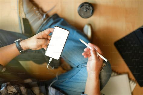 바닥에 앉아 휴대 전화를 사용하는 동안 집에서 일하는 상위 뷰 남자 사진 Unsplash의 전달하다 이미지