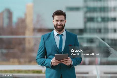 옥상에 서 있는 파란 양복에 있는 잘생긴 젊은 웃는 백인 사업가 태블릿을 들고 지붕에 대한 스톡 사진 및 기타 이미지 지붕 남자 사업가 인물 사진 Istock