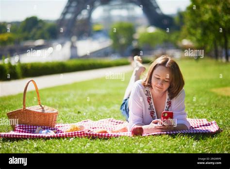 Young Woman Having Picnic Near The Eiffel Tower In Paris France Girl