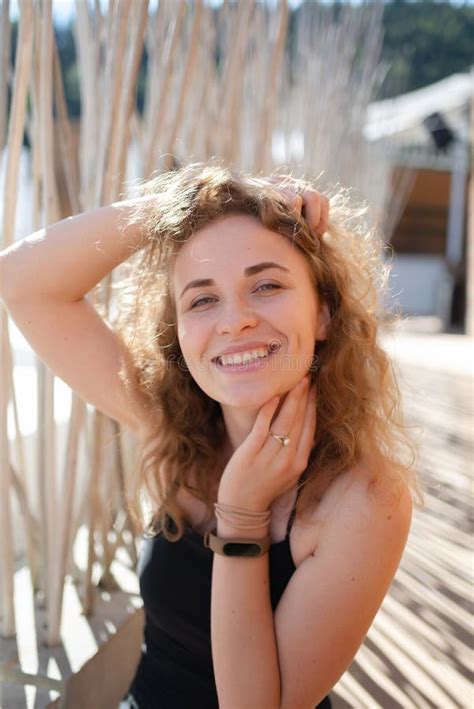 Happy Carefree Young Redhead Woman With A Cute Grin Posing With Her