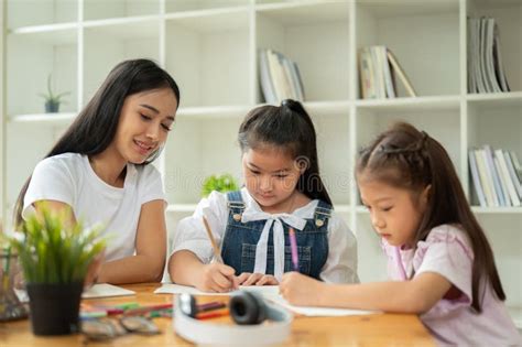 Two Adorable Young Asian Girls Are Focusing On Studying Art With A