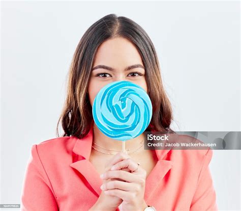 초상화 롤리팝 그리고 하얀 스튜디오 배경에 과자 설탕 자신감 넘치는 소녀를 가진 여자 얼굴 사탕 디저트 및 간식 쾌활하고 과자가
