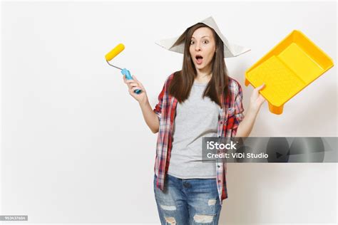 젊은 신문 모자 벽 그림을 흰색 배경에 고립 된 페인트 트레이 롤러를 들고 아름 다운 여자를 충격 악기 재건축 아파트 룸에 대 한 도구입니다 수리 가정 개념입니다 Diy에