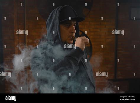 A Cloud Of Vapor Vaping Man Holding A Mod Brick Background Vape