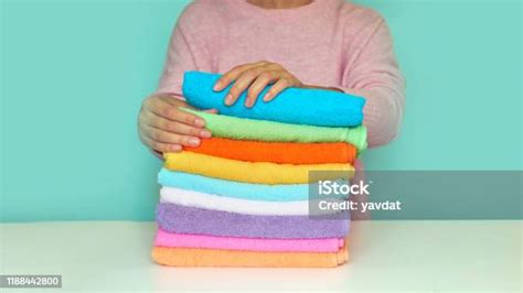 신선한 목욕 수건을 겹쳐 놓는 손의 클로즈업 파란색 배경에 고리 버들 바구니에 수건의 여러 가지 색깔롤 0명에 대한 스톡 사진 및 기타 이미지 Istock