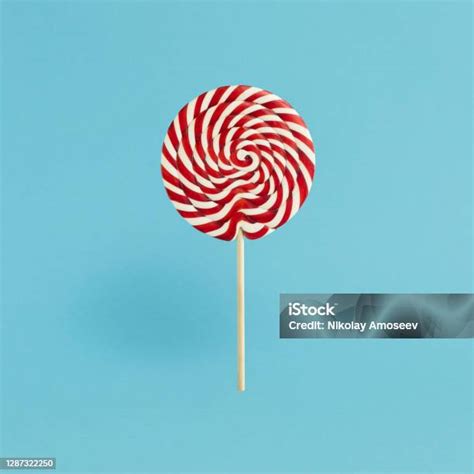 파란색 배경에 화려한 롤리팝 나무 막대기 빨간색과 흰색 나선형 어린 시절 과자 크리스마스 개념 건강에 좋지 않은 음식에 대한
