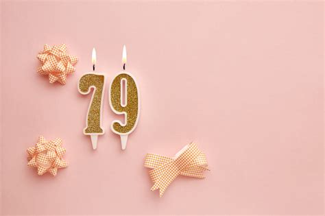 축제 장식이 있는 파스텔 핑크 배경에 숫자 79가 있는 양초 생일 축하 촛불 생일 기념일 중요한 날짜 휴일을 축하하는 개념입니다 복사 공간 기치 1에 대한 스톡 사진 및