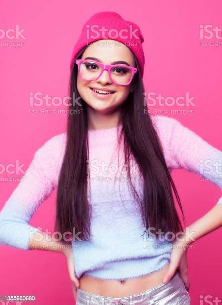 젊은 예쁜 소녀 와 갈색 머리 긴 머리 포즈 명랑 한 에 핑크 배경 라이프 스타일 사람들 개념 십대 소녀에 대한 스톡 사진 및