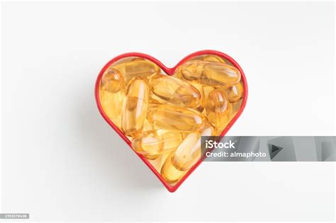 흰색 배경에 비타민 오메가 3 또는 D의 노란색 캡슐로 만든 심장 생선 기름의 노란색 알약 심장 질환 및 허혈성 뇌졸중 예방 피부 관리 우울증 치료 0명에 대한 스톡 사진