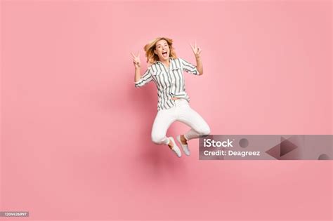 전체 길이 바디 사이즈 사진 의 쾌활 한 흥분 미친 기뻐 하는 소녀 착용 바지 바지 보여주는 더블 V기호 점프 고립 된 파스텔 색상 배경 브이에 대한 스톡 사진 및 기타