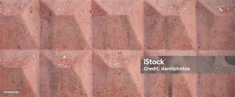 금이 간 분홍색 페인트 클로즈업이 있는 오래된 소련 콘크리트 울타리의 간단한 조각 페인트가 벗겨진 오래된 울타리가 있는 최소한의 배경 특이한 디자인의 단색 울타리가 있는