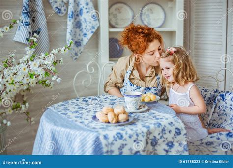 Junge Mutter Küssen Ihre Tochter am Tisch Auf Einer Küche Stockbild Bild von essen liebe