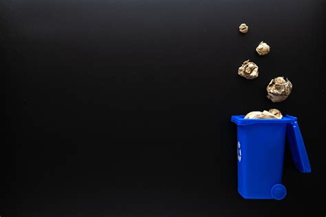 재활용 용지 플라스틱과 유리를 재활용하기위한 파란색 쓰레기통은 검은 색 배경에 휴지통 할 수 있습니다 쓰레기 쓰레기를 폐기하고 환경을 절약하기 위해 용기를 보관하십시오