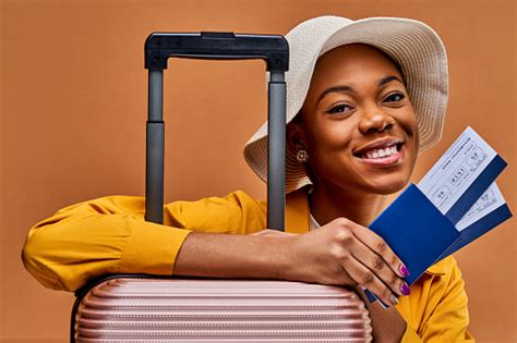 흰 모자를 쓴 한 여성이 가방에 기대어 있는 파란색 여권을 손에 들고 두 장의 티켓을 들고 있다 여행 컨셉 비행기 티켓에 대한 스톡 사진 및 기타 이미지 Istock