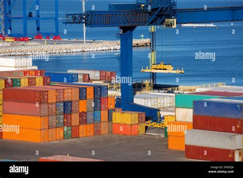 Heavy Lifting Crane For Unloading And Sorting Multi Colored Containers At The Seaport Dock By