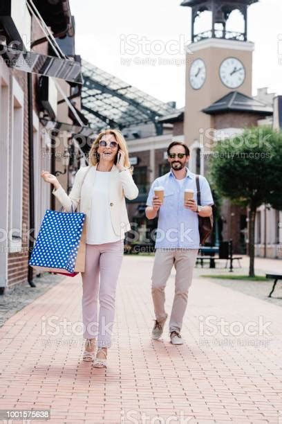 스마트폰으로 얘기 하 고 개최 쇼핑백 거리에 일회용 커피 컵을 들고 남편 아내 2명에 대한 스톡 사진 및 기타 이미지 2명 거리 나름 Istock