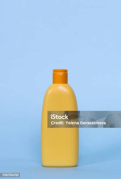 파란색 배경에 노란색 플라스틱 화장품 병 어린이 헤어 샴푸 바디 로션 또는 자외선 차단제 크림 세로 복사 공간 0명에 대한 스톡 사진 및 기타 이미지 Istock