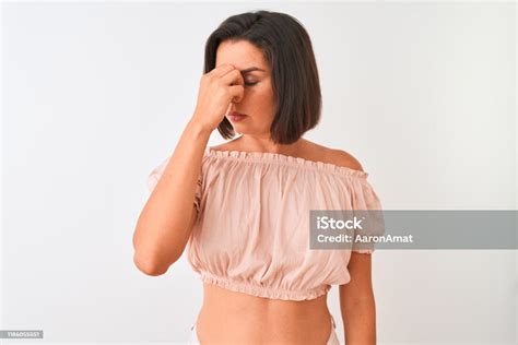 고립 된 흰색 배경에 서 캐주얼 한 티셔츠를 입고 젊은 아름다운 여성은 피로와 두통을 느끼는 코와 눈을 문질러 피곤 스트레스와 좌절 개념 T 셔츠에 대한 스톡 사진 및 기타