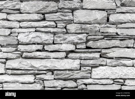 An Aged Stone Wall With Irregularly Shaped Stones Stacked Horizontally