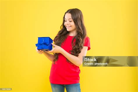 그녀를 위한 특별한 선물 노란색 배경에 파란색 선물 팩행복 작은 아이 복싱 데이에 선물 상자를 들고 귀여운 어린 소녀 아름답게 포장 된 생일 선물 상자와 함께 미소
