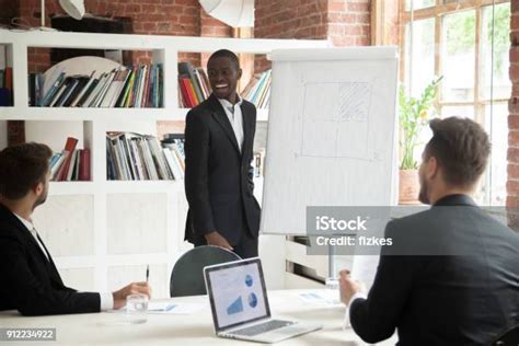 사무실에서 기업인을 프레 젠 테이 션을 주는 친절 한 아프리카 코치 미소 프로젝트 관리자에 대한 스톡 사진 및 기타 이미지 프로젝트 관리자 노트북 디자인 전문가