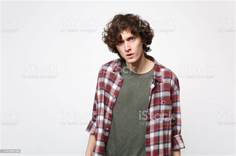 캐주얼 서 서와 스튜디오에서 흰색 벽 배경에 고립 된 찾고 카메라에 불쾌 한 자극 된 젊은 남자의 초상화 사람들은 진심으로 감정 라이프 스타일 개념입니다 복사 공간을 모의